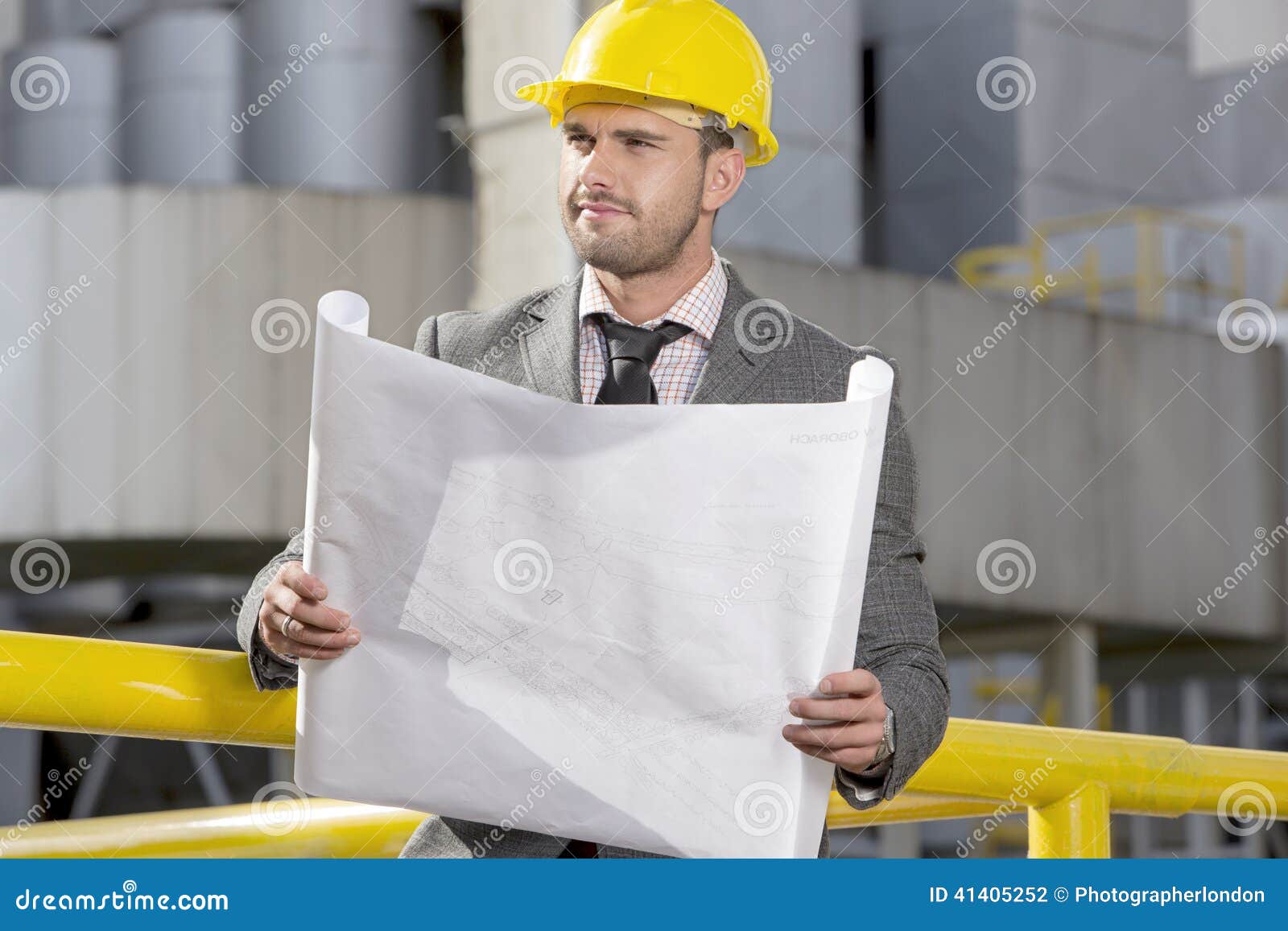 Young Businessman Holding Blueprint while Looking Away at Construction ...