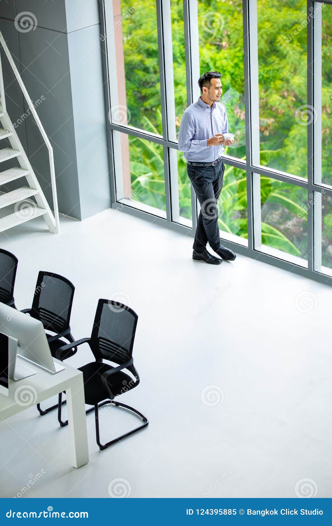 Young Businessman Holding a Cup of Coffee Standing the Window Lo Stock ... Young Businessman Holding a Cup of Coffee Standing the Window Lo Stock ...