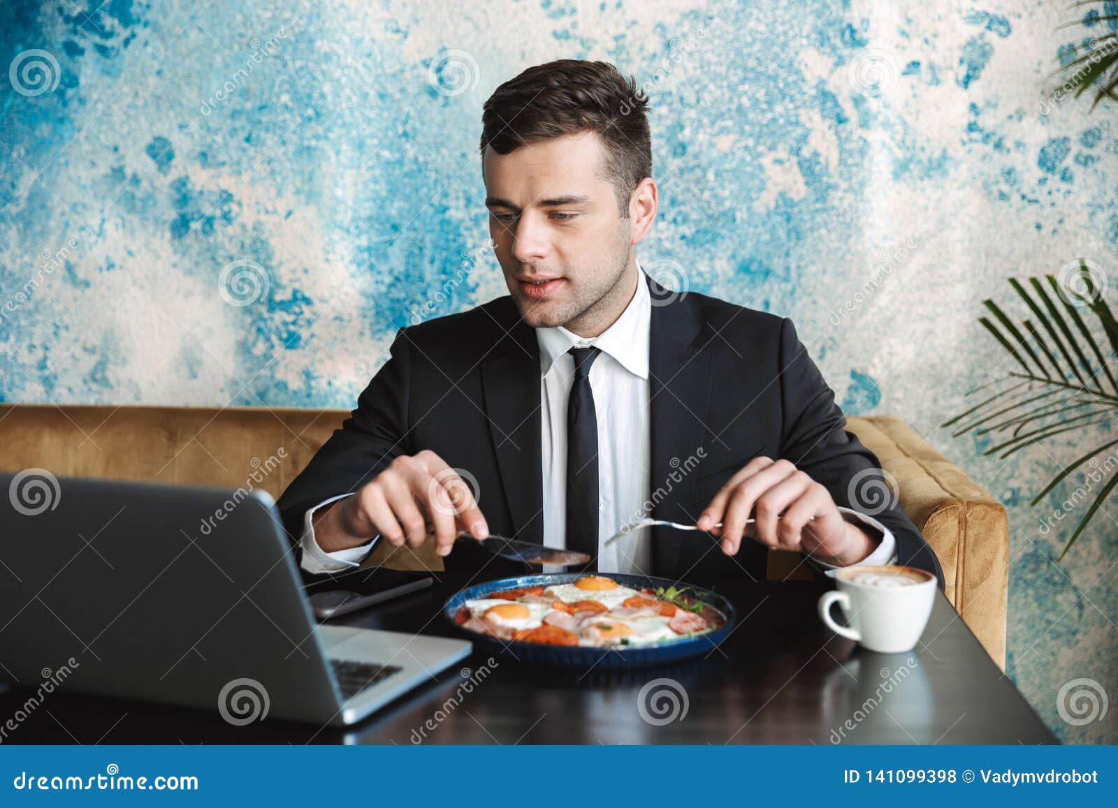 Young Businessman Sitting in Cafe Using Laptop Computer Have a ...
