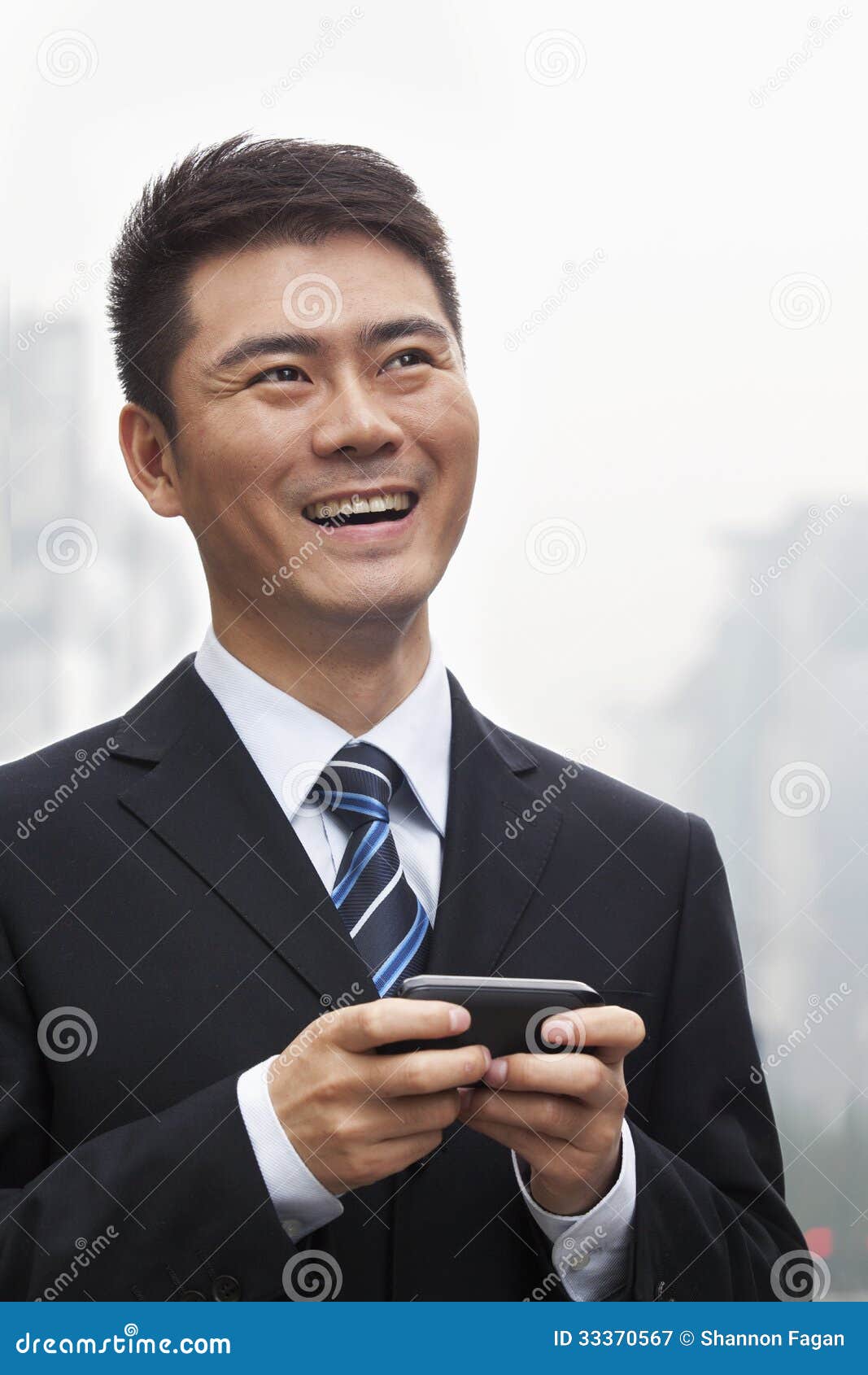Young Businessman Smiling and Using a Smart Phone Stock Image - Image ...