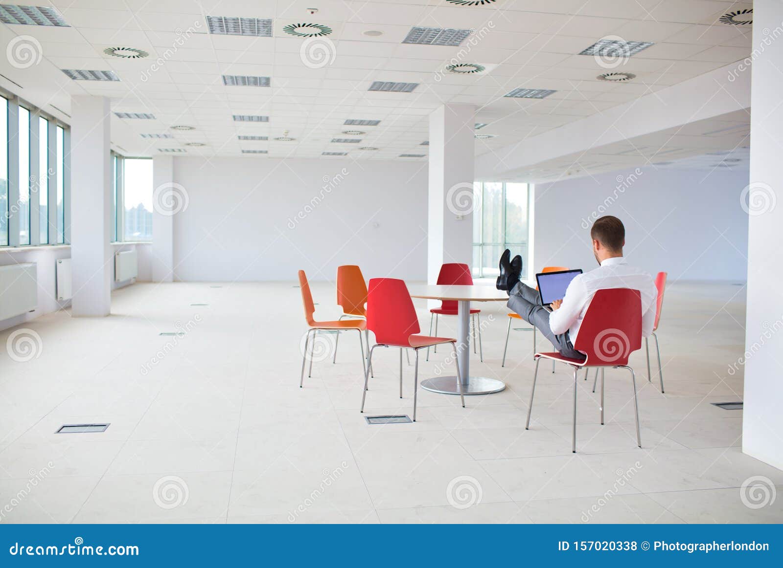 Rear View of Young Businessman Using Laptop at New Office Stock Photo ... Rear View of Young Businessman Using Laptop at New Office Stock Photo ...