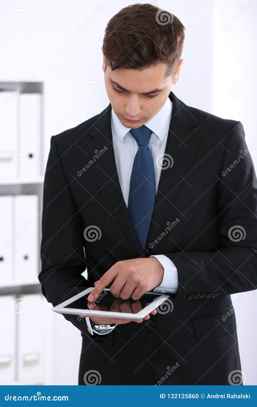 Young Businessman Using Tablet Computer while Standing Straight in ...