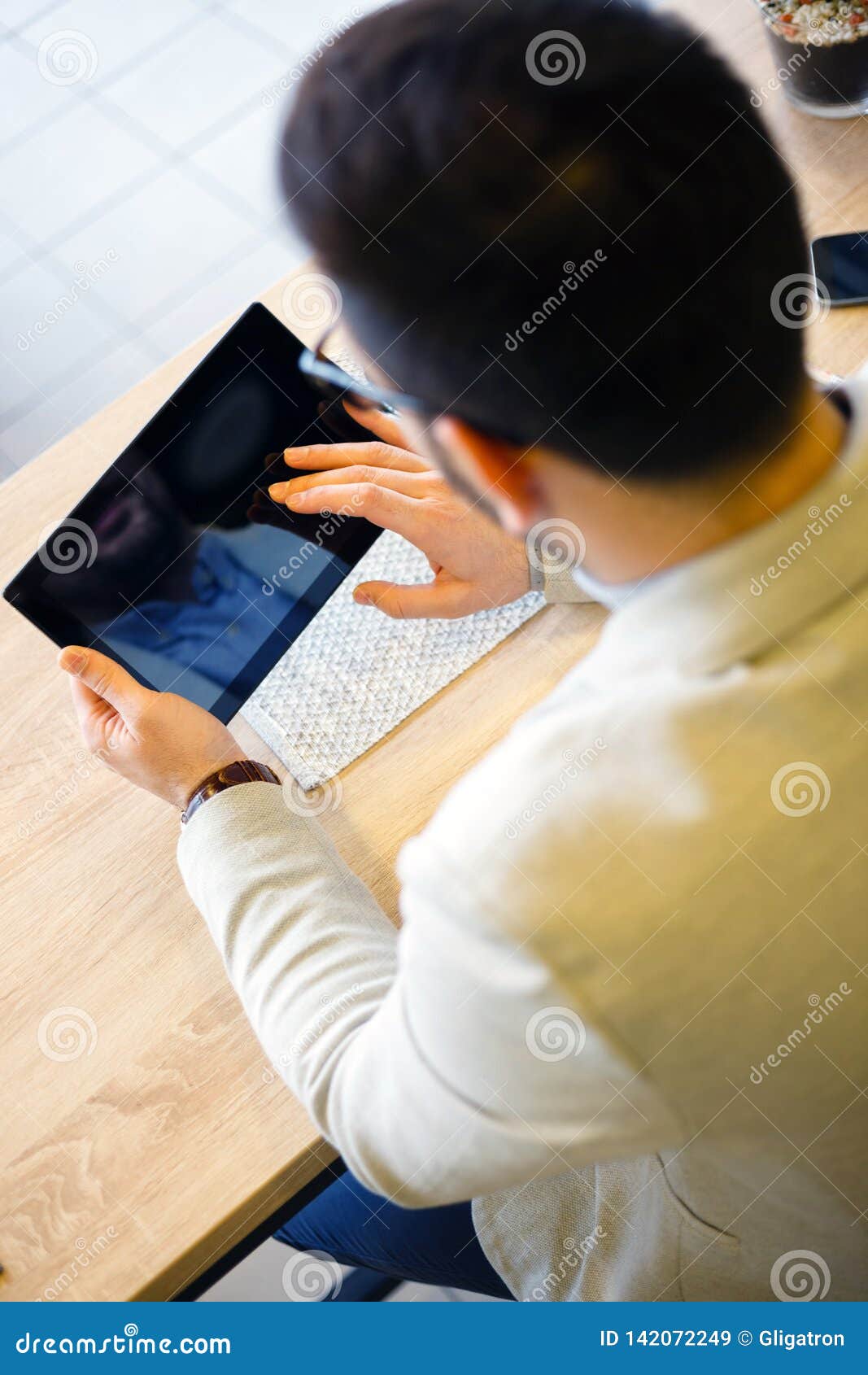 Young Businessman Using a Tablet while Working in a Modern Coffee Shop ...