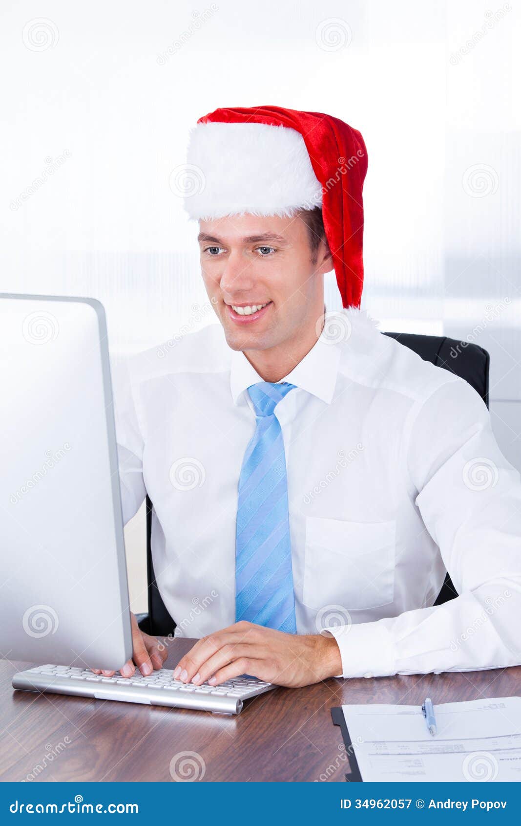 Young Businessman Wearing Santa Hat Using Computer in Office Stock ...