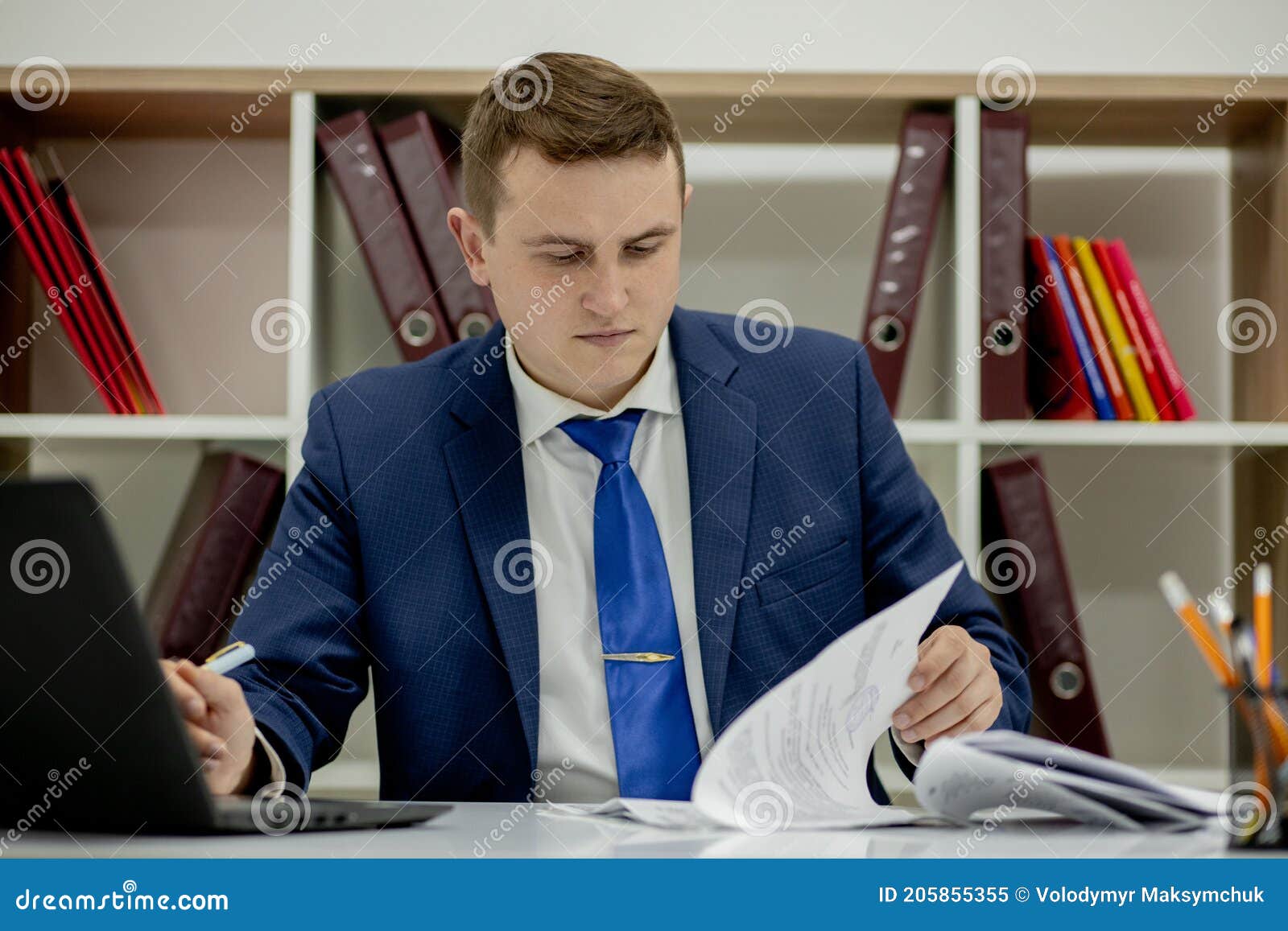 Young Businessman Working with Documents Looking through Papers in ...