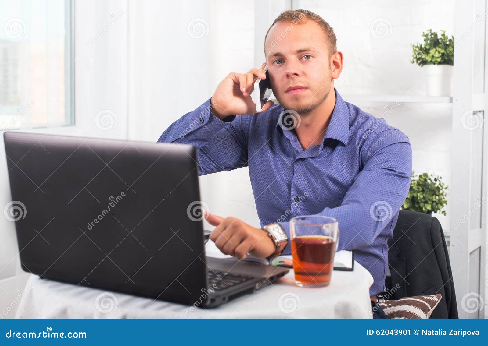 Young Businessman Working in Office, Sitting at a Table, Looking ...
