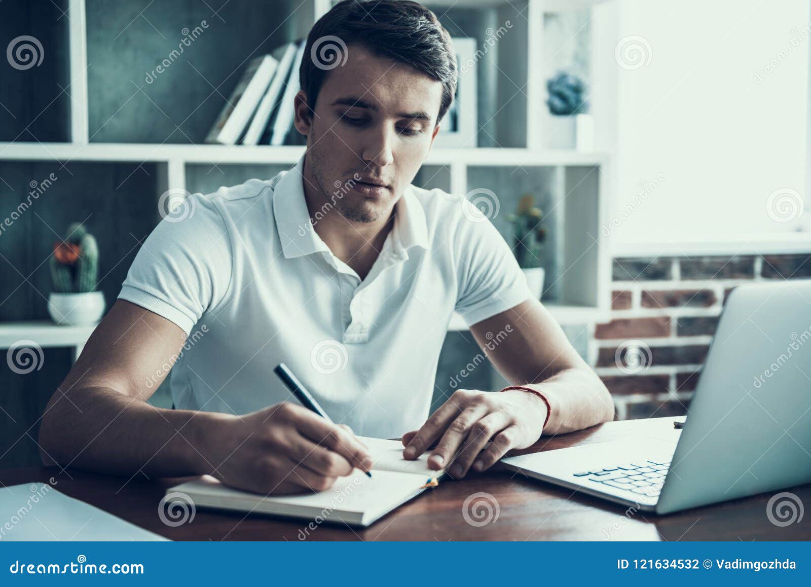 Young Businessman Writing Notes and Using Laptop. Stock Photo - Image ...
