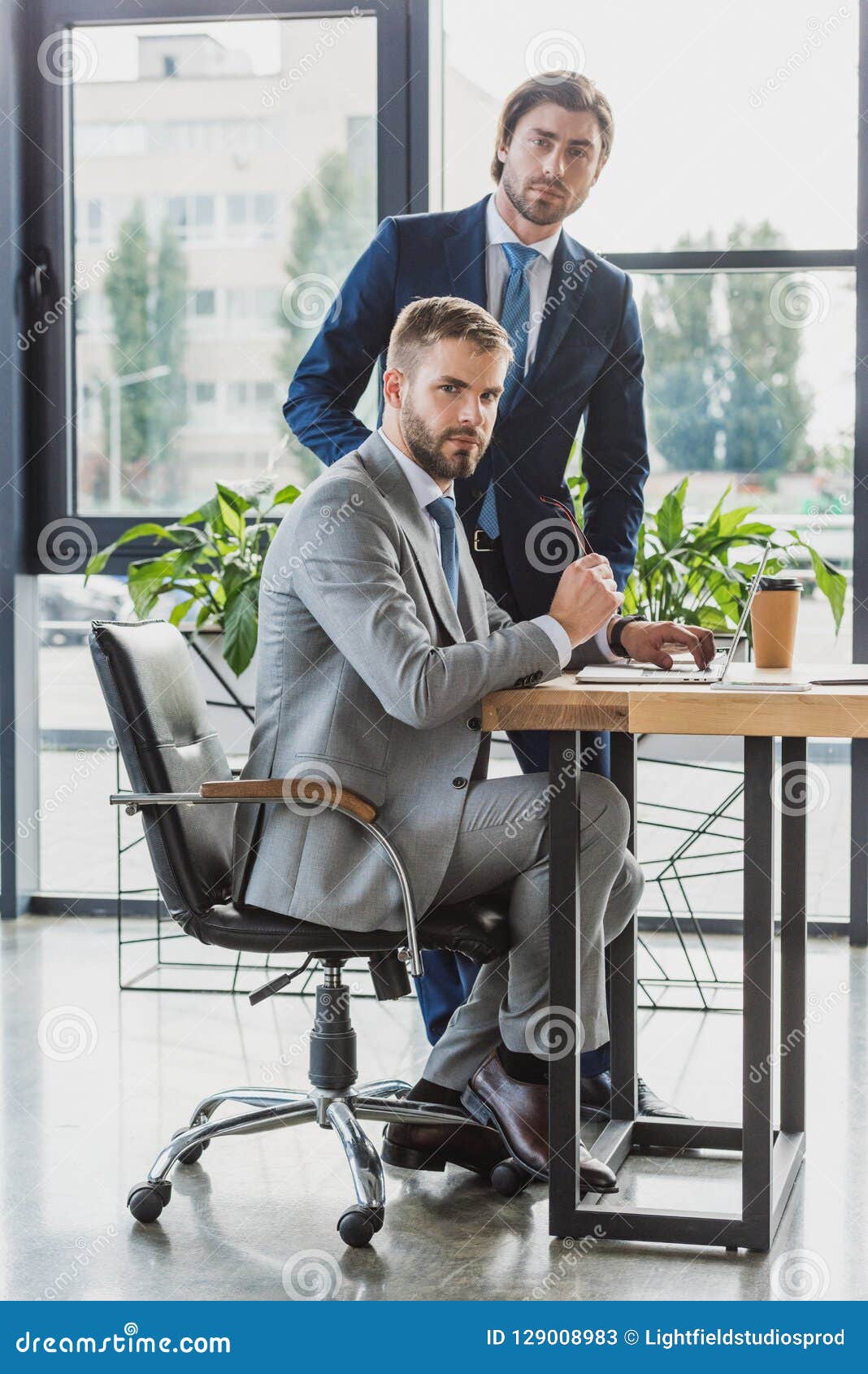 Young Businessmen in Suits Looking at Camera while Working Together ...