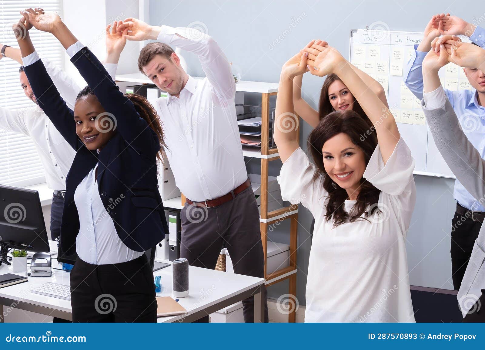 Young Businesspeople Doing Stretching Exercise at Workplace Stock Image ...