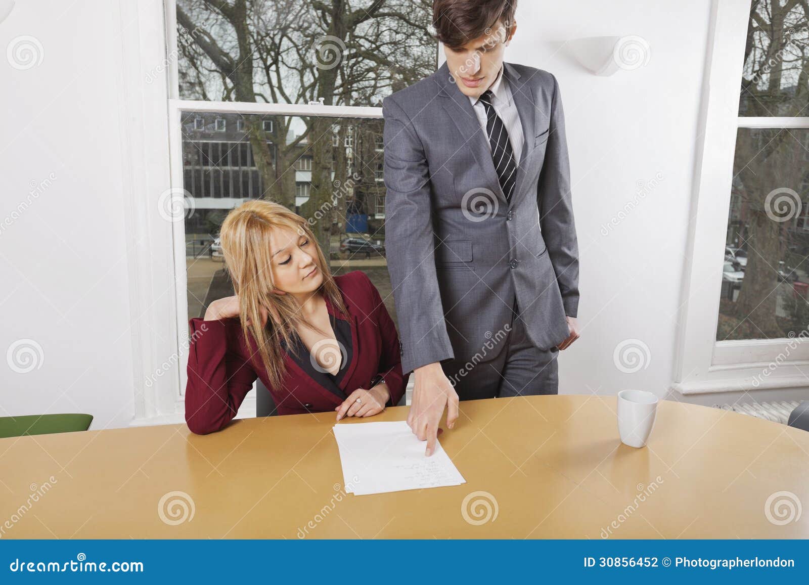 Young Businesspeople Reviewing Documents at Conference Table Stock ...