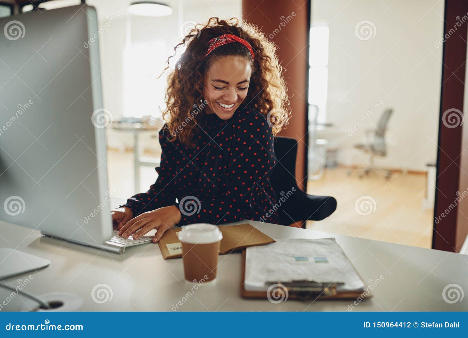 Young Businesswoman Smiling while Working at Her Office Desk Stock ...