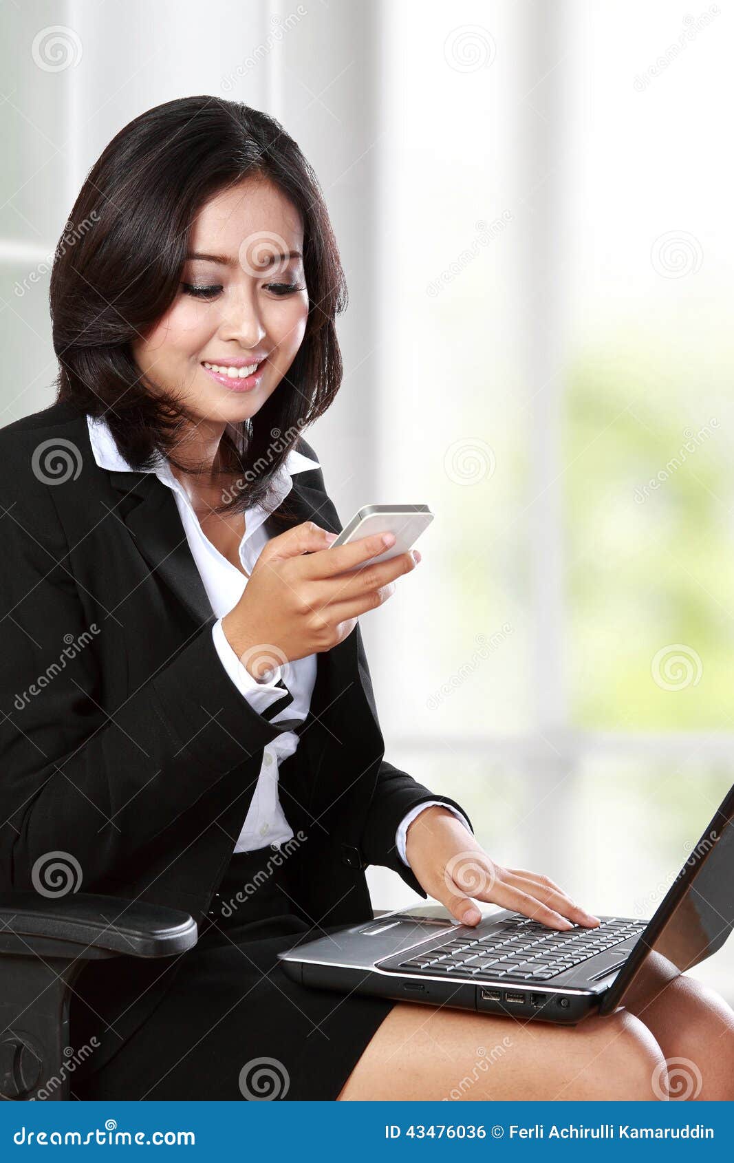 Young Businesswoman Using Mobile Phone while Working in the Office ... Young Businesswoman Using Mobile Phone while Working in the Office ...