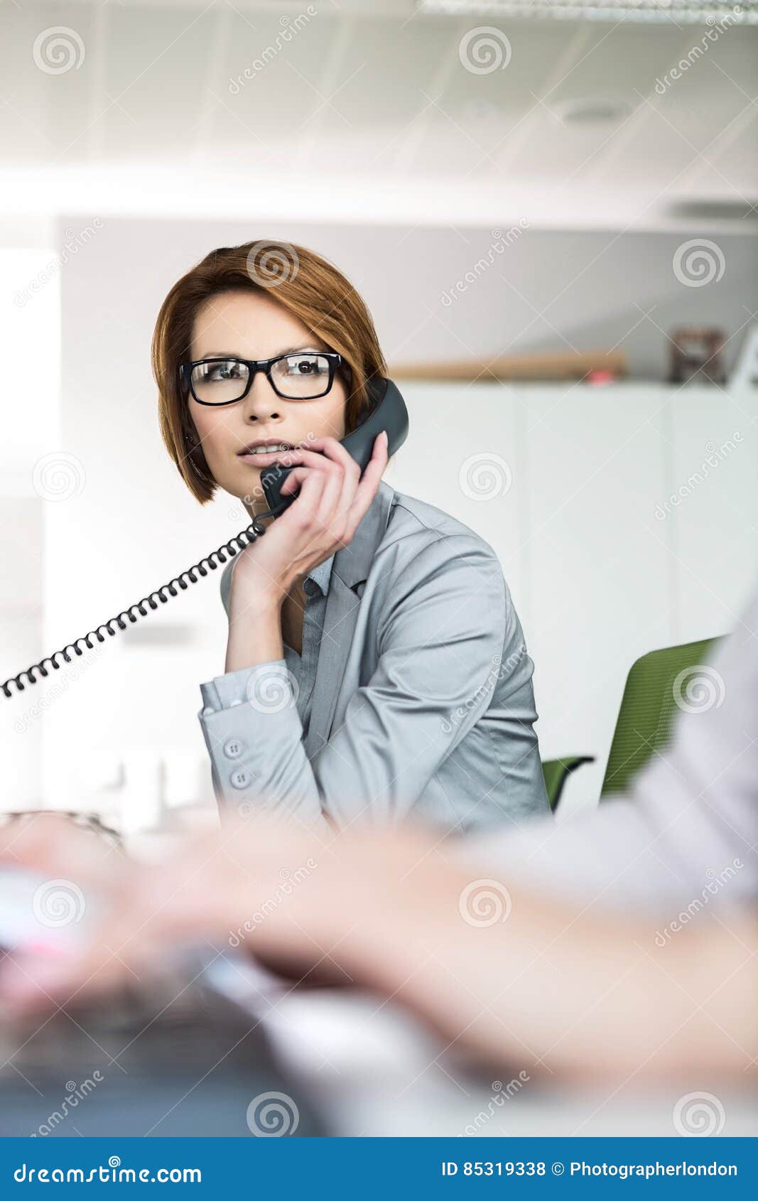 Young Businesswoman Using Telephone in Office Stock Photo - Image of ...