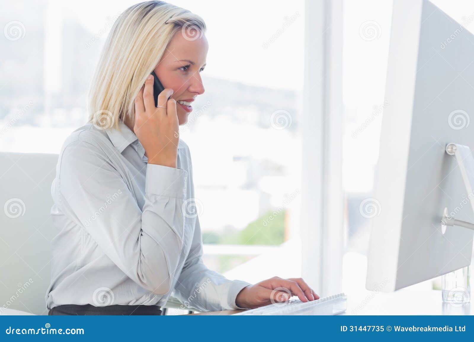 Young Businesswoman Working on Computer on the Phone Stock Image ...