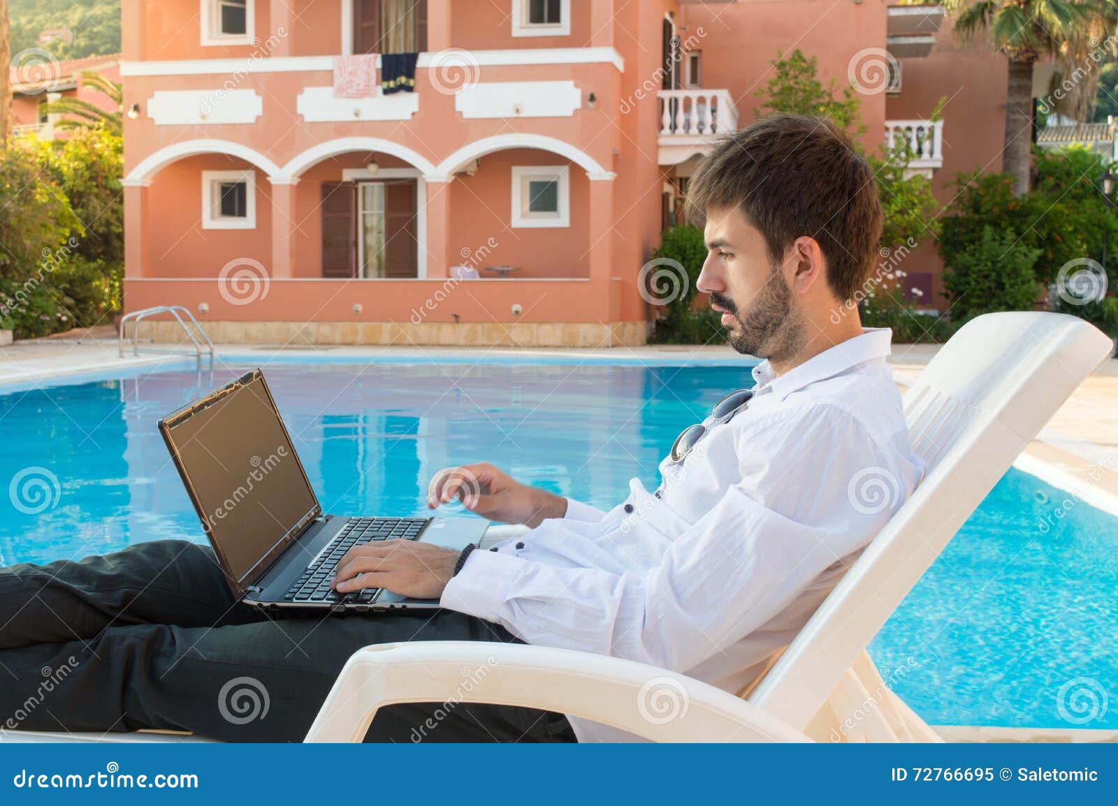 Young Bussines Man Working on His Lap Top by the Pool Stock Image ...