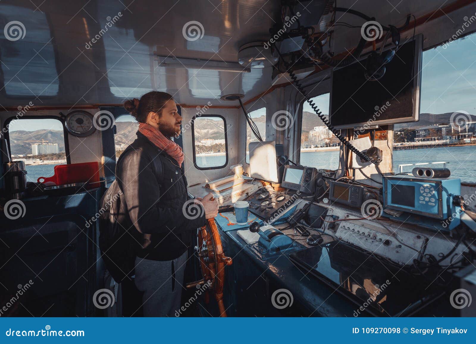 Young Capitan with Beard Stands at the Helm and Controls the Ship, View ...