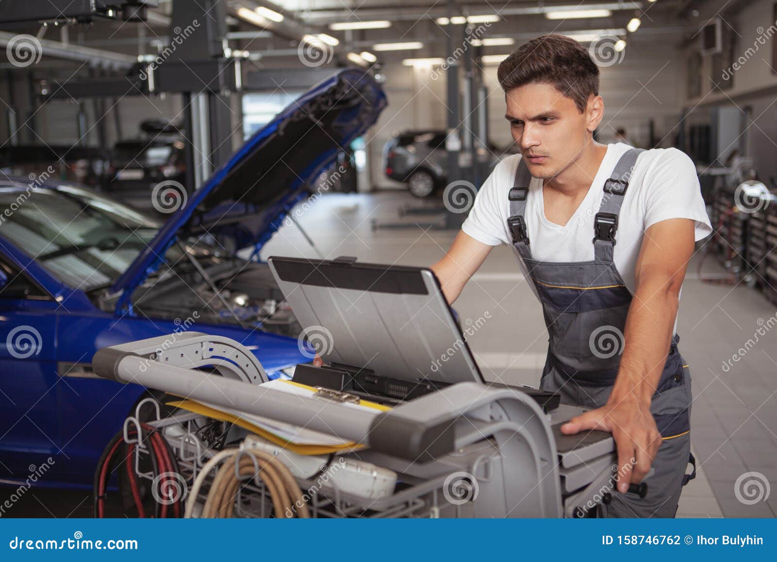 Young Handsome Car Mechanic Repairing Vehicle in His Garage Stock Photo ...