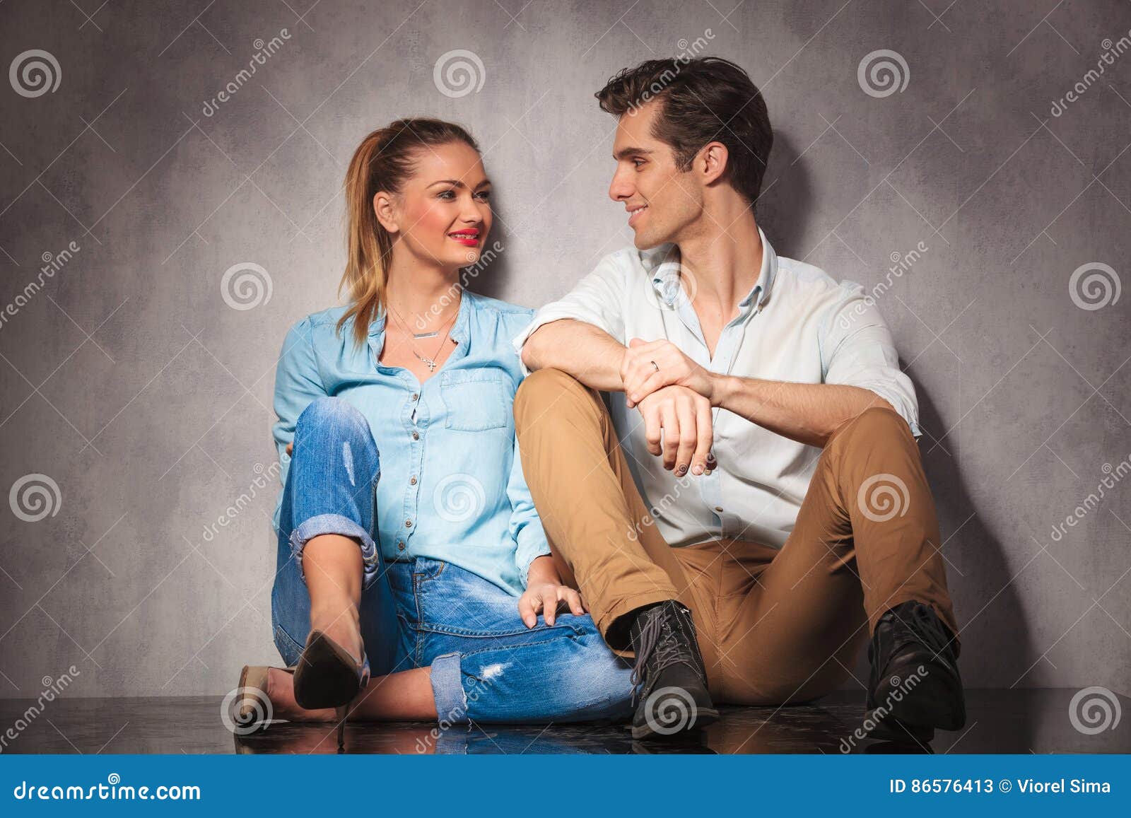 Young Casual Seated Couple Laughing at Each Other Stock Image - Image ...