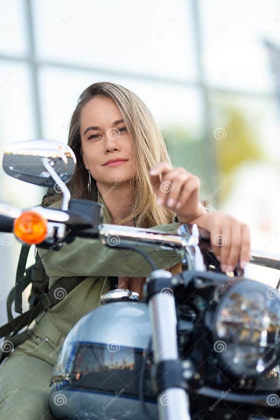 Young Caucasian Biker Woman Posing On Her Bike After Driving And Looking At Camera Stock Image