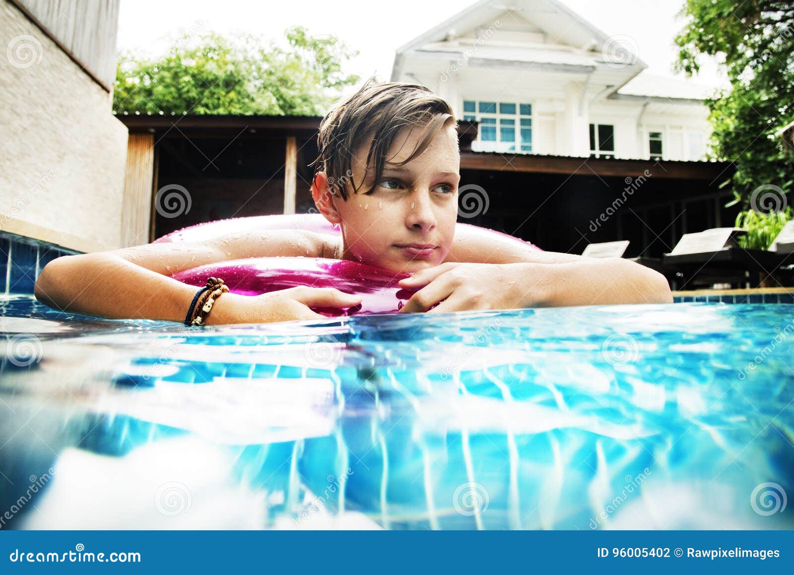 Young Caucasian Boy Enjoying Floating in the Pool with Tube Stock Photo ...