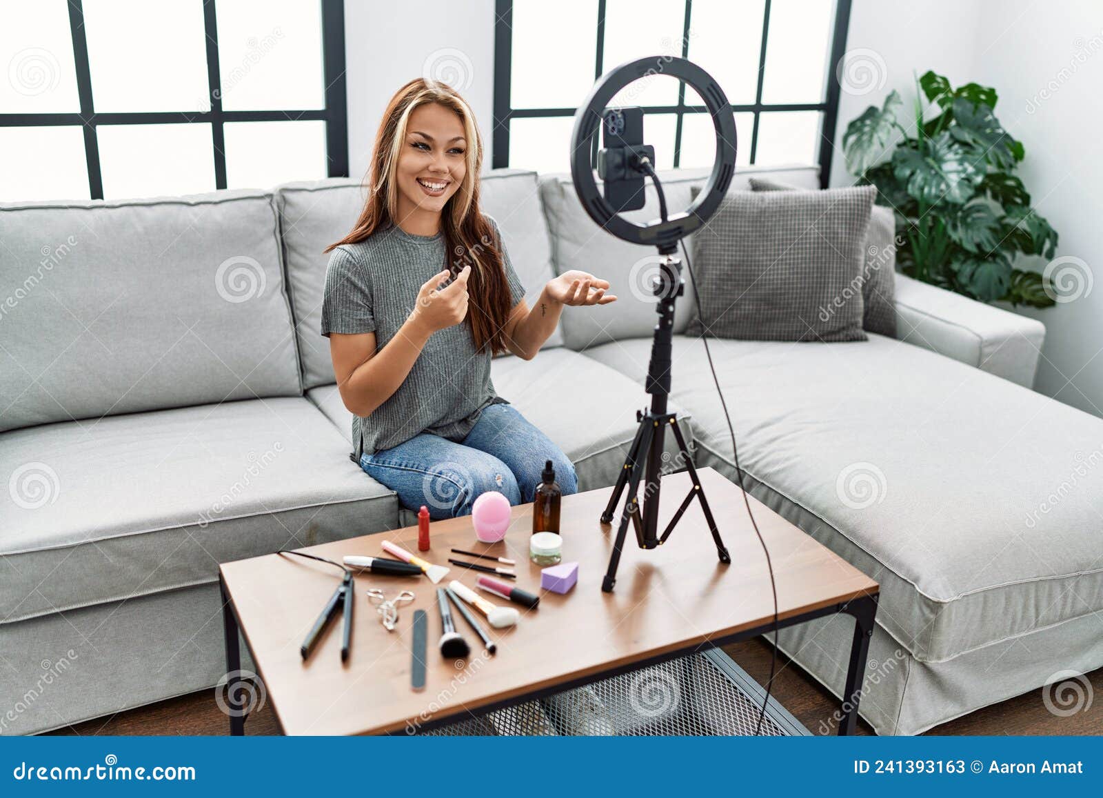 Young Caucasian Girl Making Makeup Tutorial Sitting on the Sofa at Home ...
