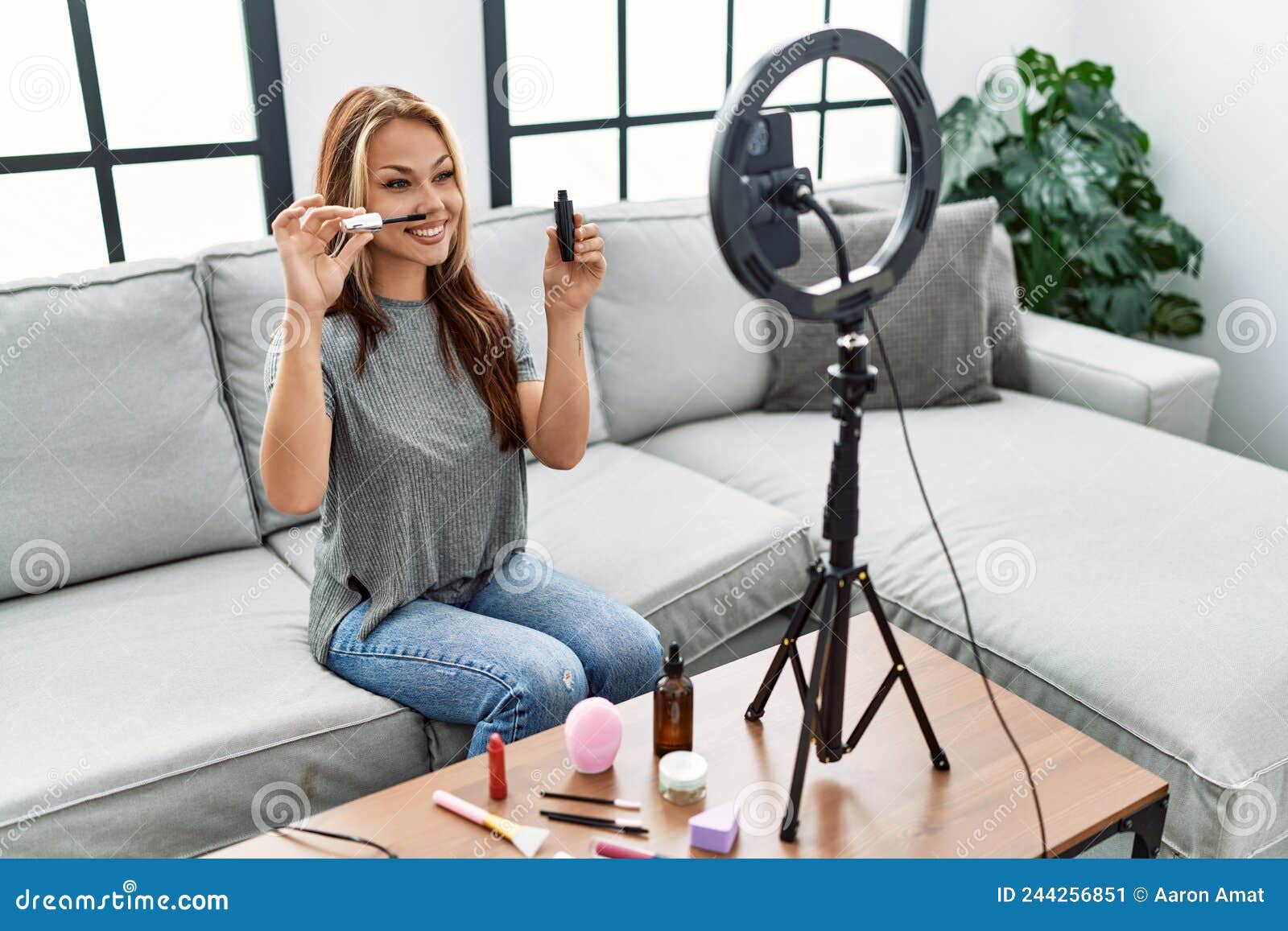 Young Caucasian Girl Making Makeup Tutorial Sitting on the Sofa at Home ...