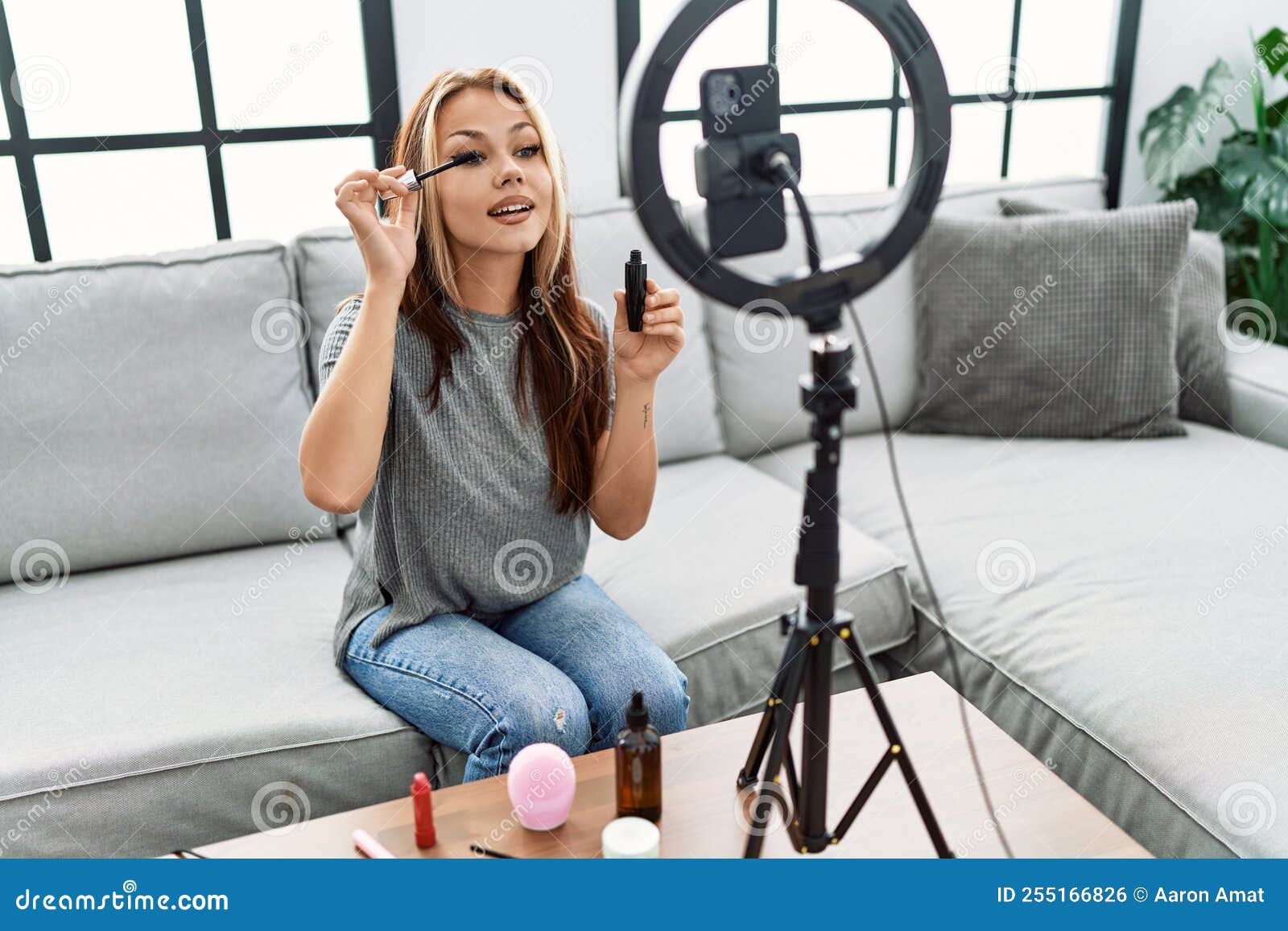 Young Caucasian Girl Making Makeup Tutorial Sitting on the Sofa at Home ...