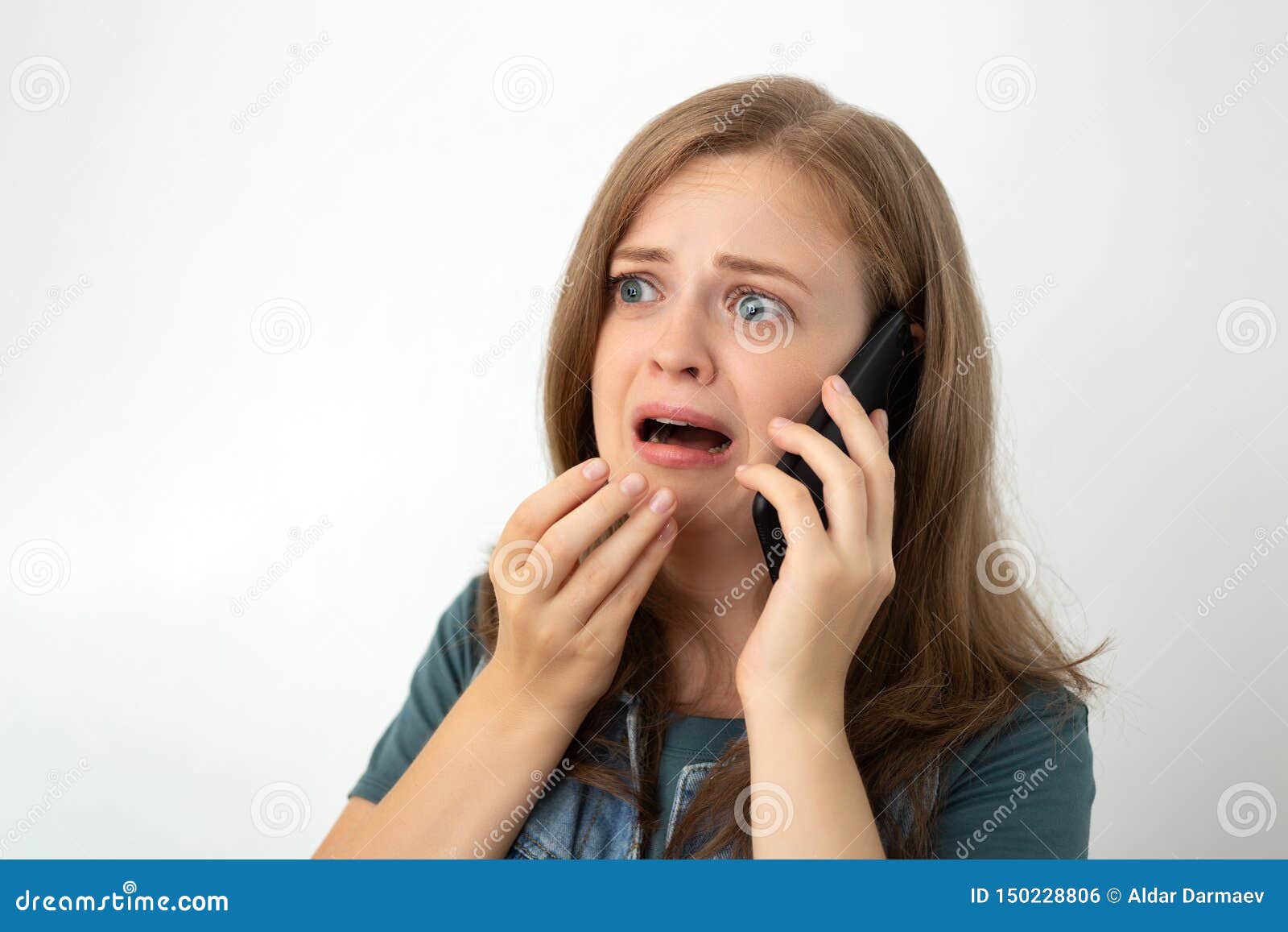 Young Caucasian Girl Woman Is Talking On The Mobile Phone Looks Scared