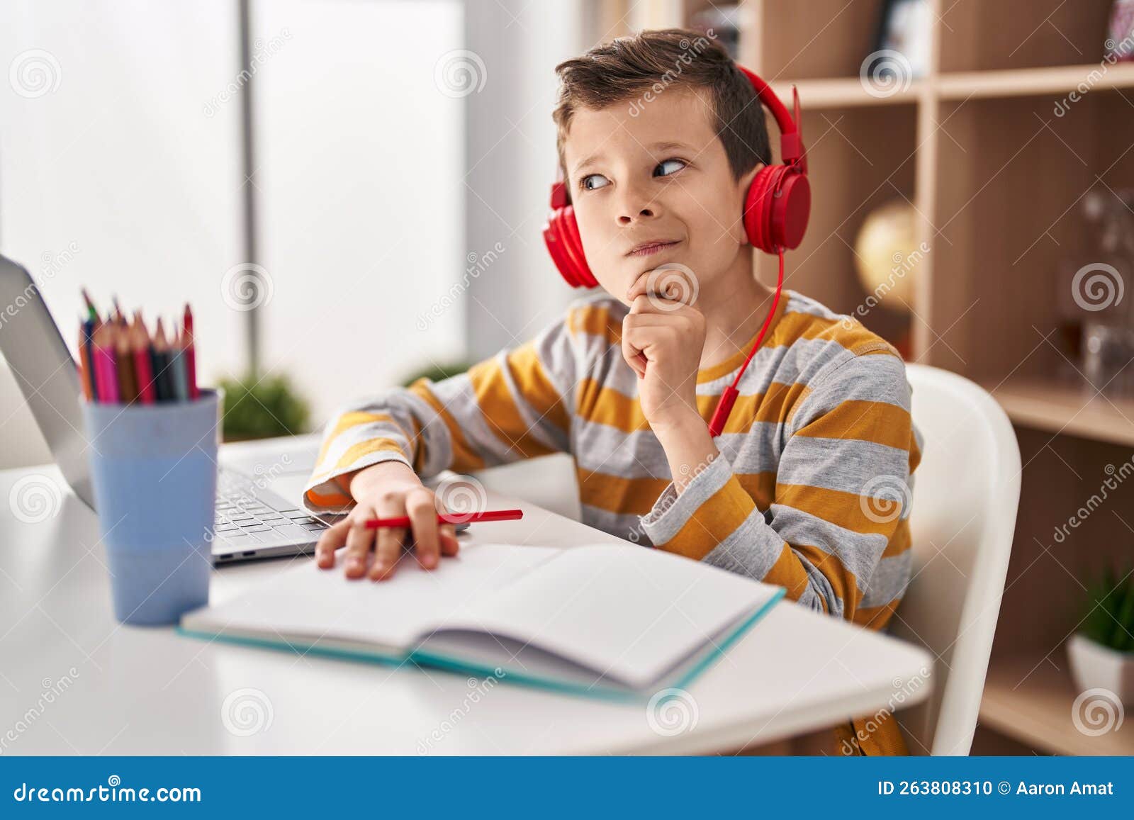 Young Caucasian Kid Doing Homework at Home Serious Face Thinking about ...