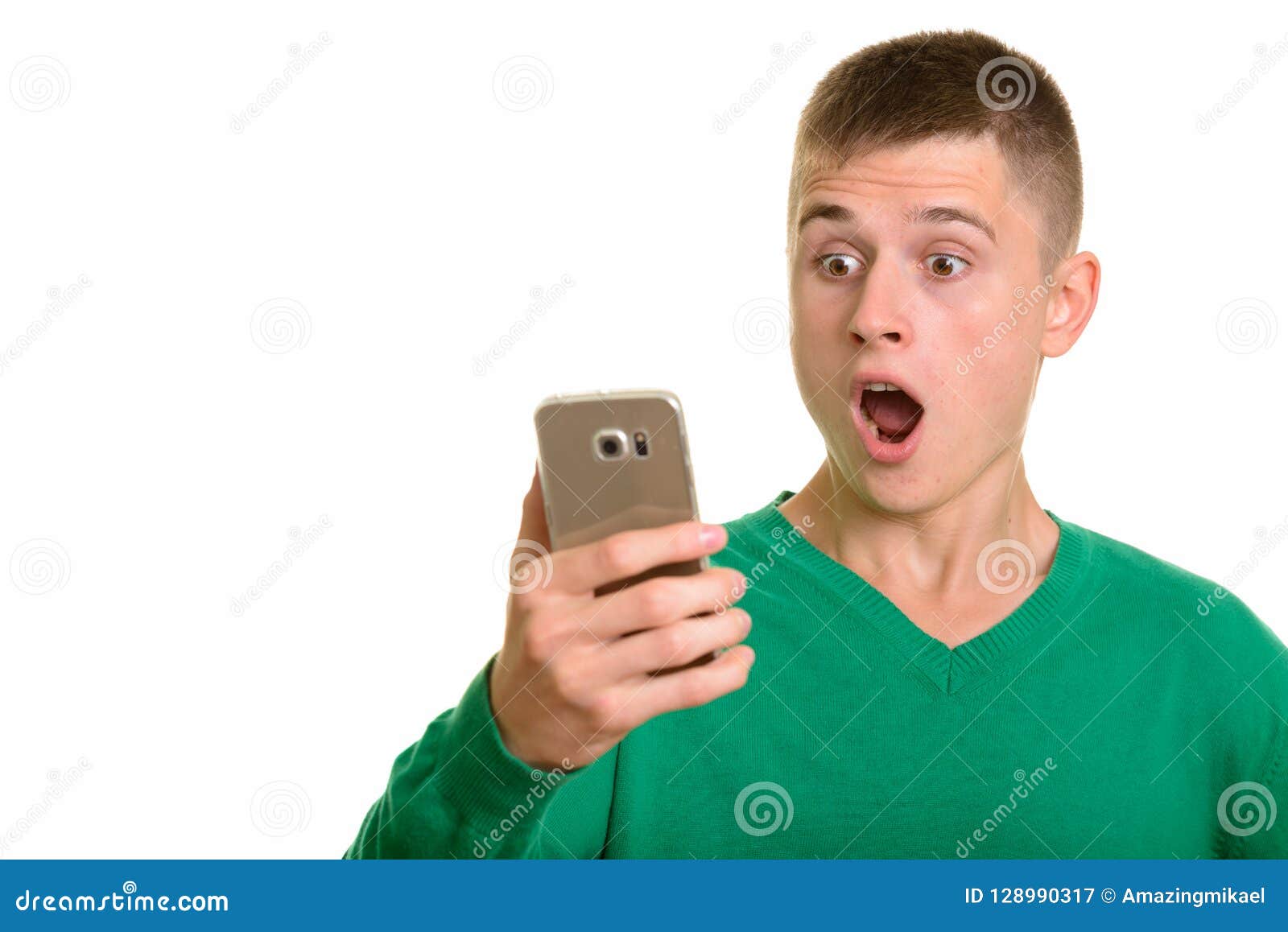 Young Caucasian Man Holding Mobile Phone Looking Surprised Stock Image