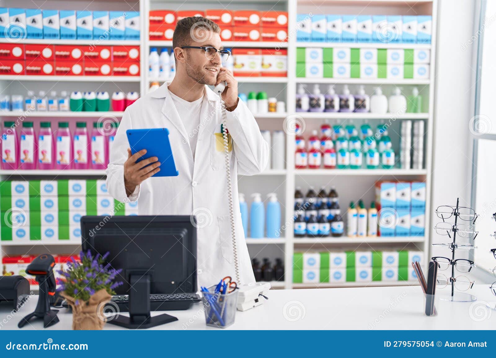 Young Caucasian Man Pharmacist Talking on Telephone Using Touchpad at ...