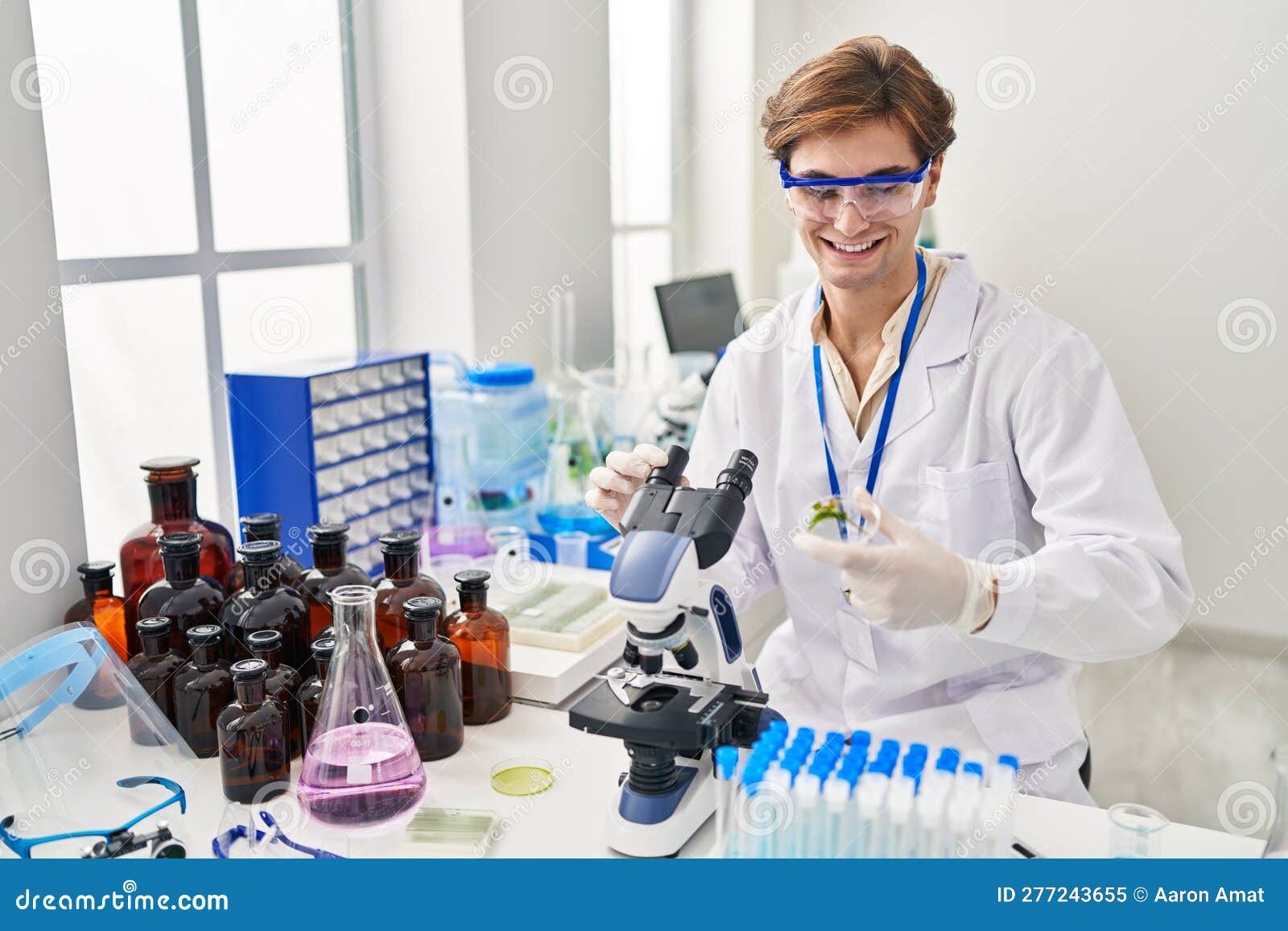 Young Caucasian Man Scientist Using Microscope Holding Plant Sample at ...