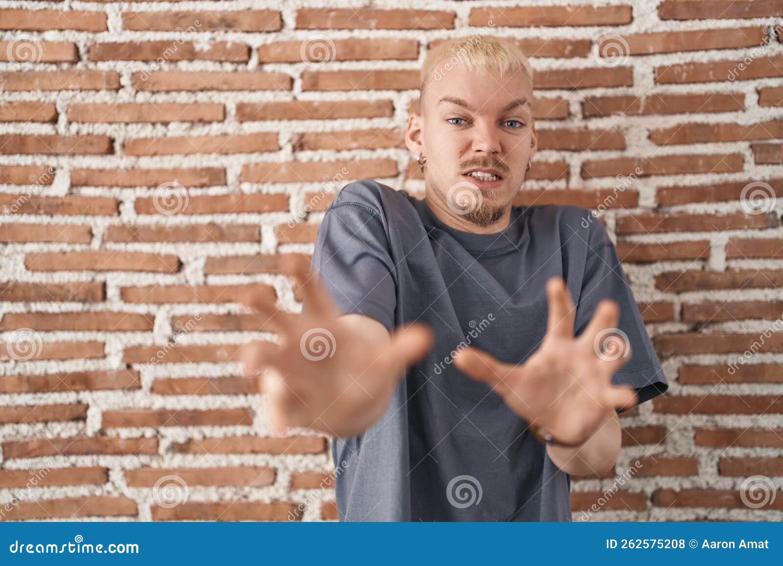 Young Caucasian Man Standing Over Bricks Wall Afraid and Terrified with ...