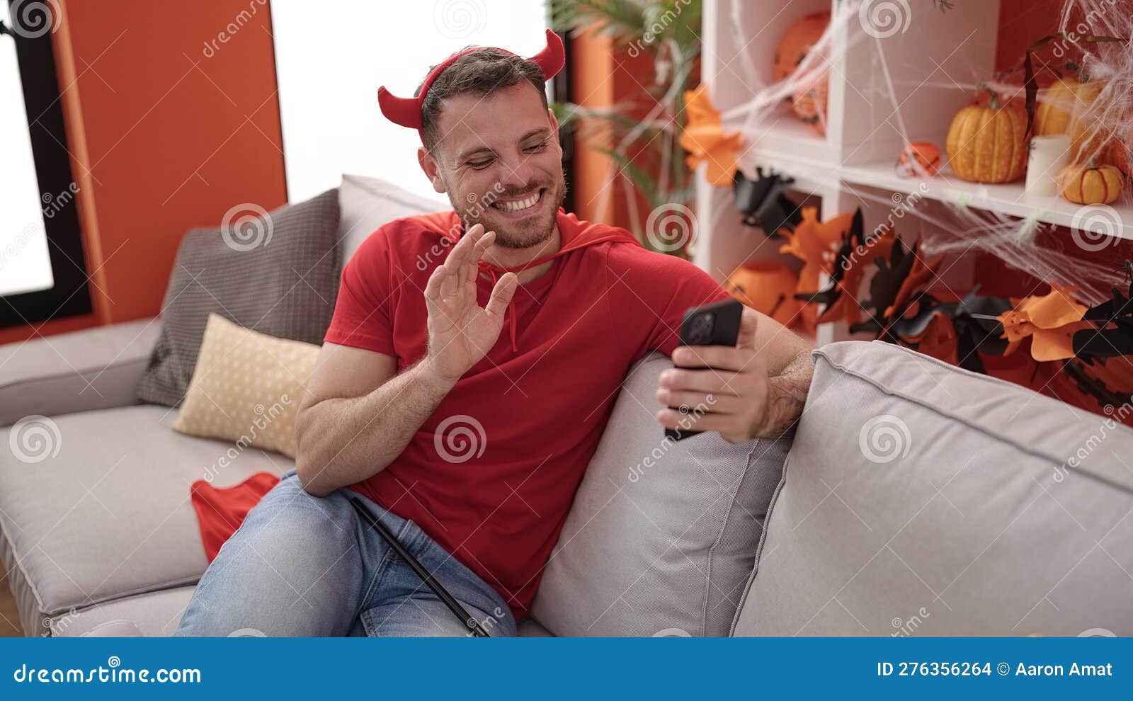Young Caucasian Man Wearing Devil Costume Sitting on the Sofa Doing ...