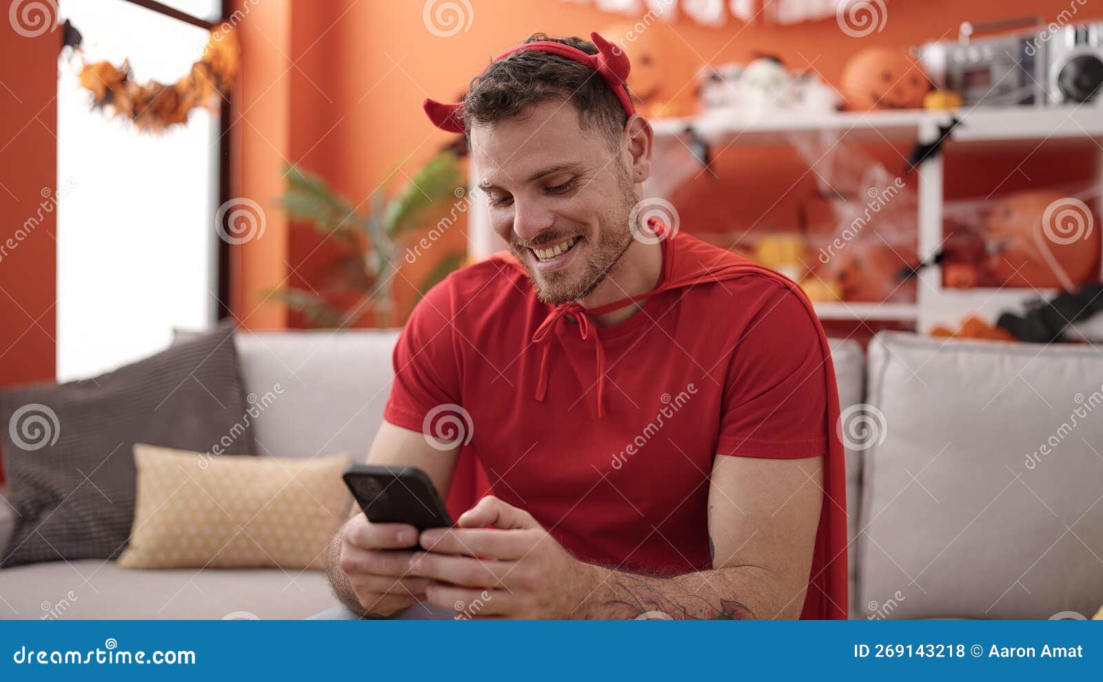 Young Caucasian Man Wearing Devil Costume Sitting on the Sofa Using ...