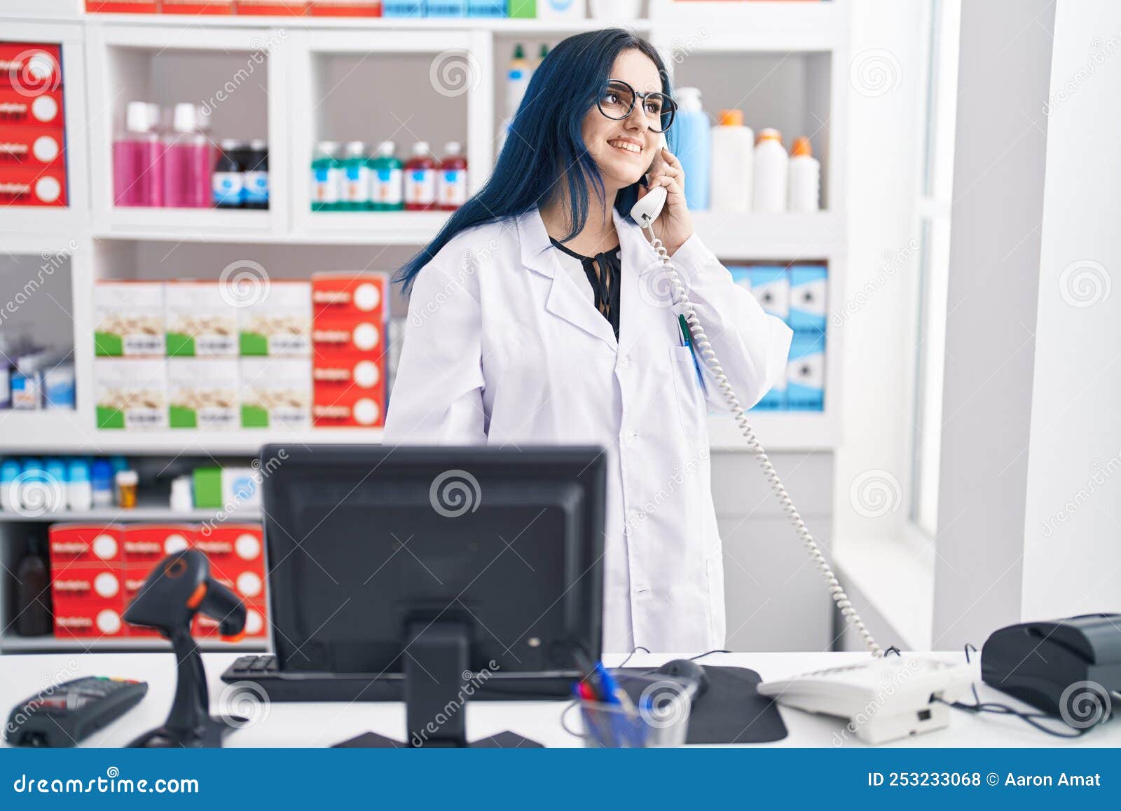 Young Caucasian Woman Pharmacist Talking on Telephone Using Computer at ...