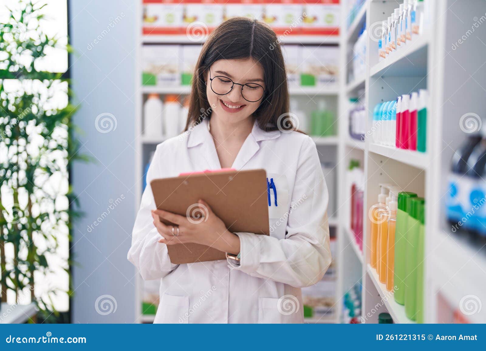 Young Caucasian Woman Pharmacist Writing on Document at Pharmacy Stock ...