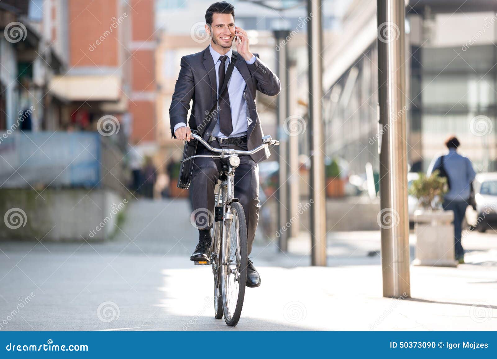 Young Cheerful Businessman Riding a Bicycle and Using Phone Stock Photo ...