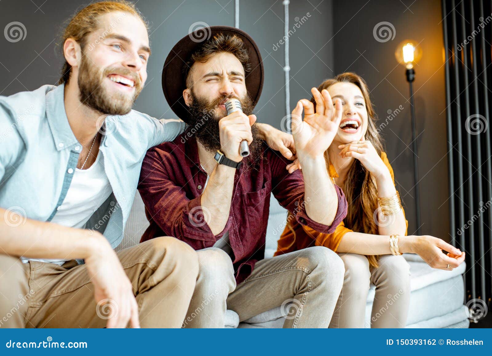 Friends singing at home stock photo. Image of sofa, room - 150393162