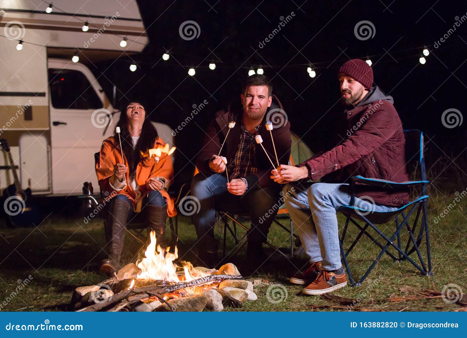 Young and Cheerful Friends Sitting Around Camp Fire Stock Photo - Image ...