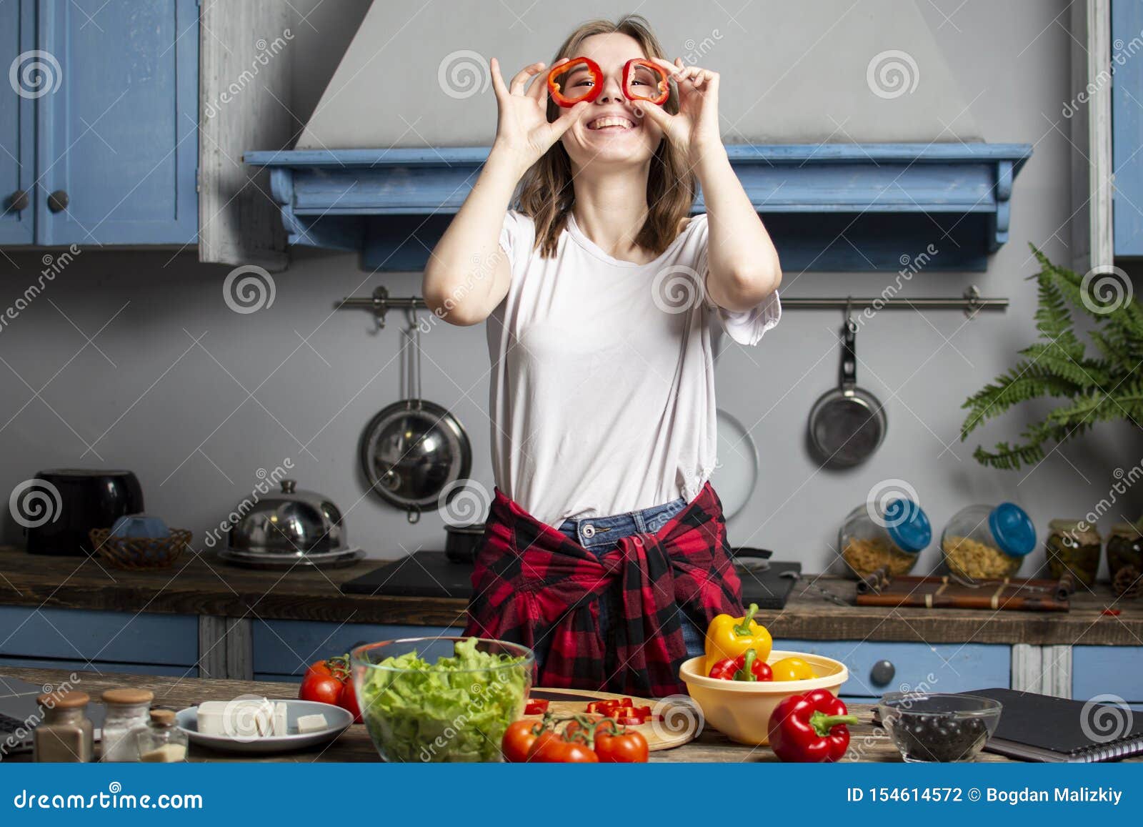 Young Girl Prepares A Vegetarian Salad In The Kitchen The Process Of