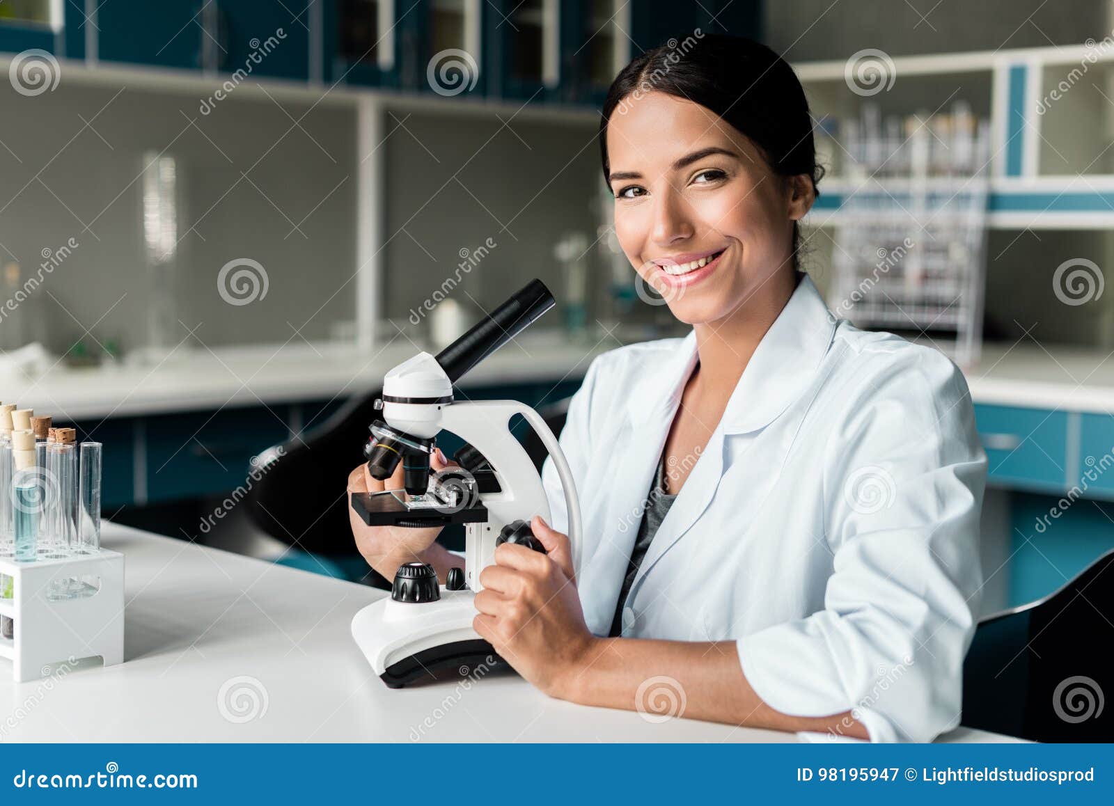Young Chemist in White Coat Working with Microscope and Smiling at ...