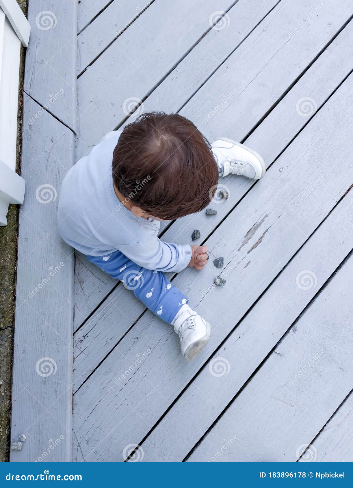 Young Child Playing with Stones on Wooden Floor Stock Photo - Image of ...