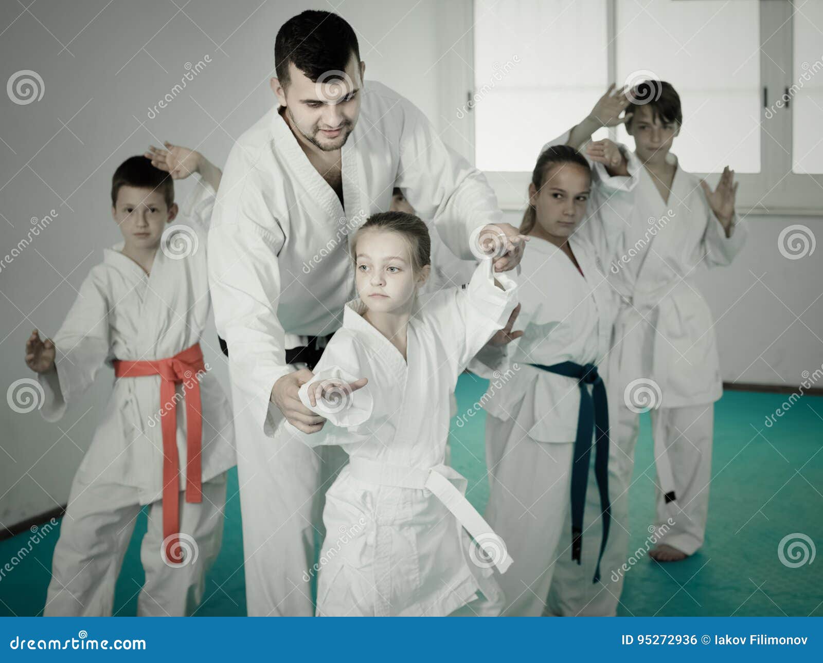 Young Children Doing Karate Kicks with Male Coach Stock Photo - Image ...