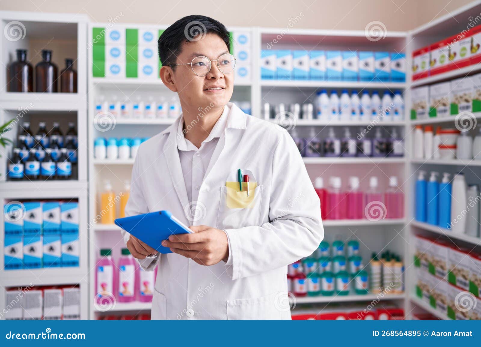 Young Chinese Man Pharmacist Using Touchpad Working at Pharmacy Stock ...