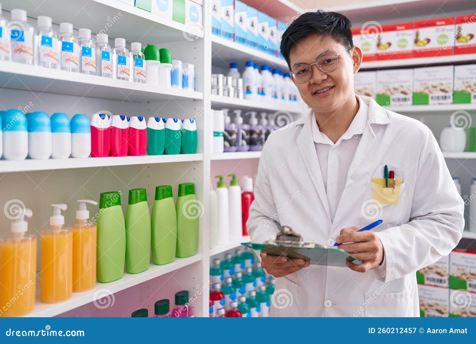 Young Chinese Man Pharmacist Writing on Document at Pharmacy Stock ...