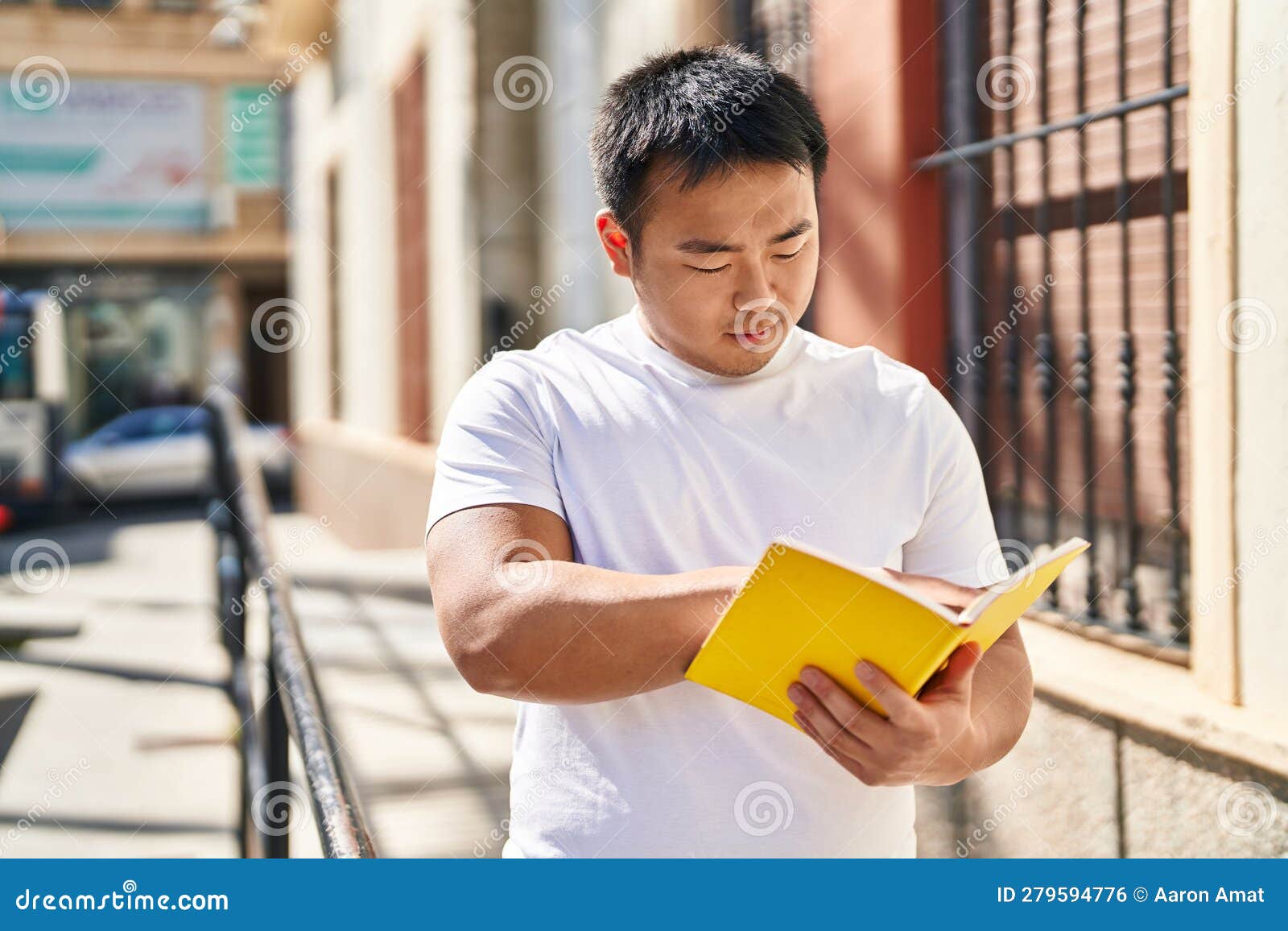 Young Chinese Man Reading Book at Street Stock Photo - Image of looking ...