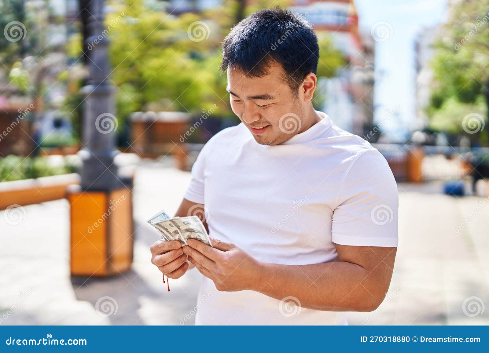 Young Chinese Man Smiling Confident Counting Dollars at Park Stock ...