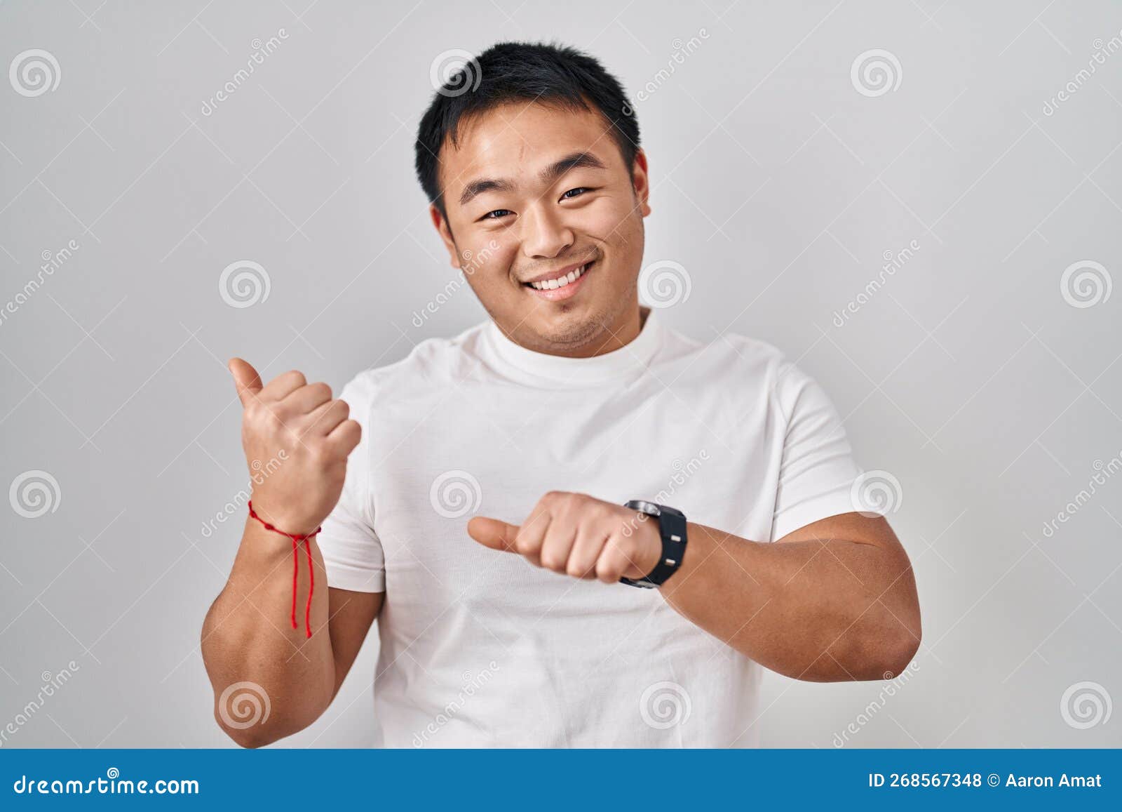 Young Chinese Man Standing Over White Background Pointing To the Back ... Young Chinese Man Standing Over White Background Pointing To the Back ...