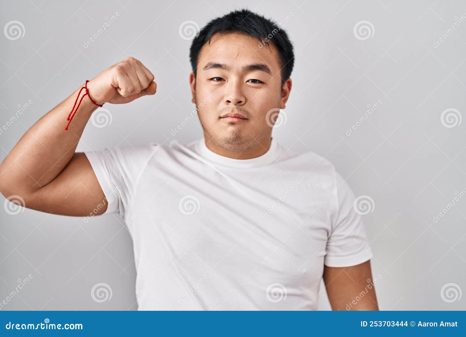 Young Chinese Man Standing Over White Background Strong Person Showing ... Young Chinese Man Standing Over White Background Strong Person Showing ...
